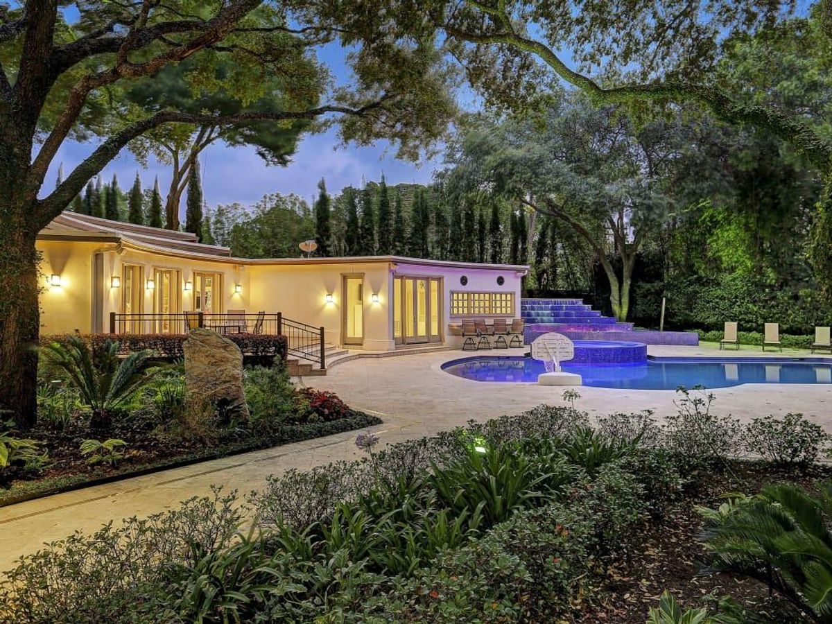 The exterior of the home, which faces a large pool. - CultureMap Houston