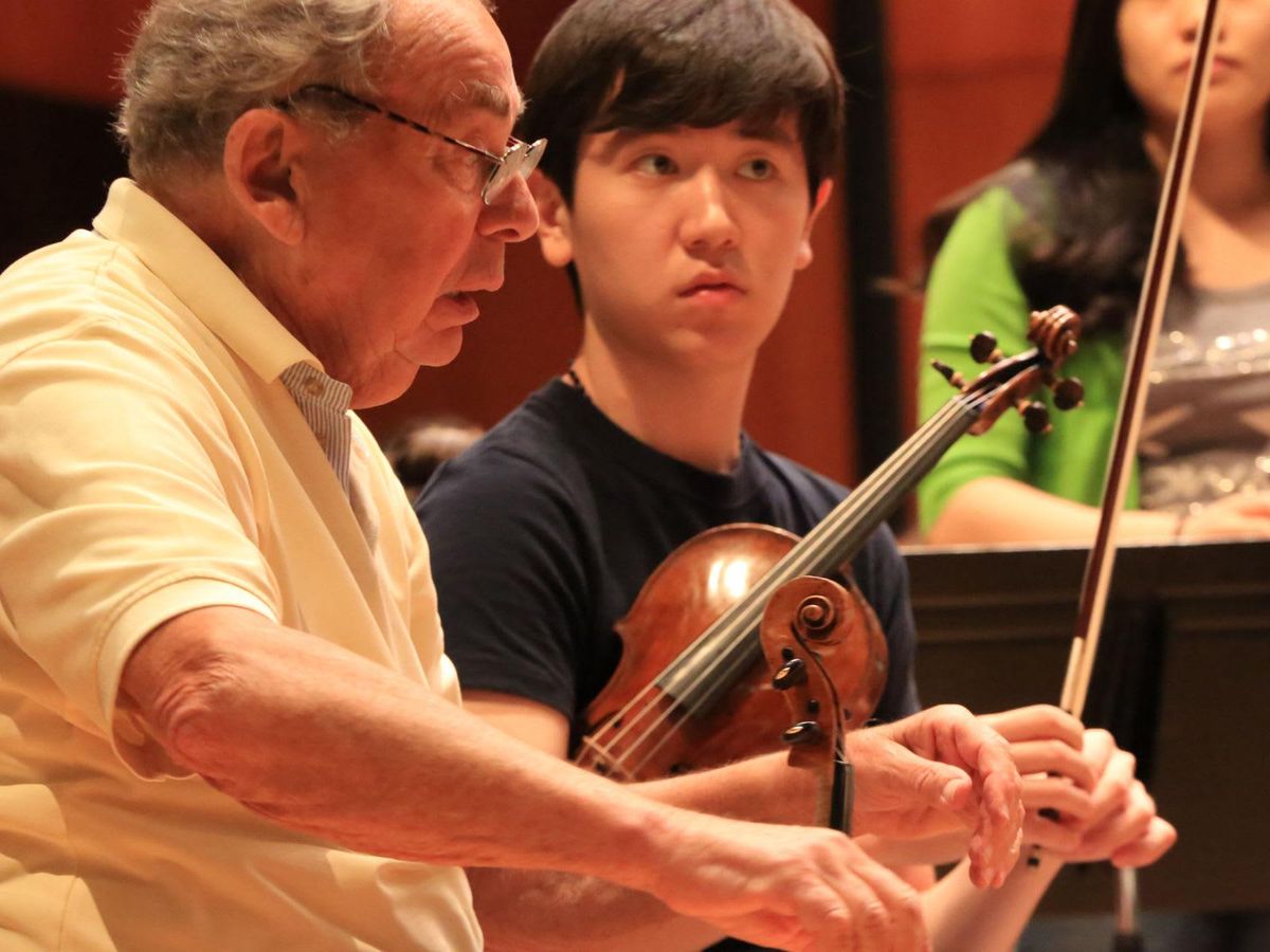 Leon Spierer gives advice to an orchestra fellow in rehearsal at the ...
