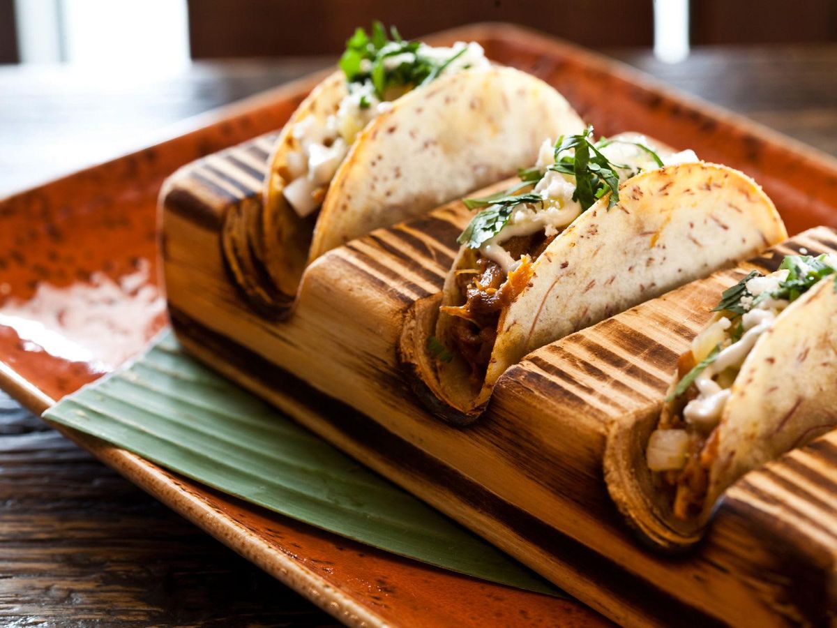 Pork taquitos come wrapped in taro tacos. - CultureMap Houston