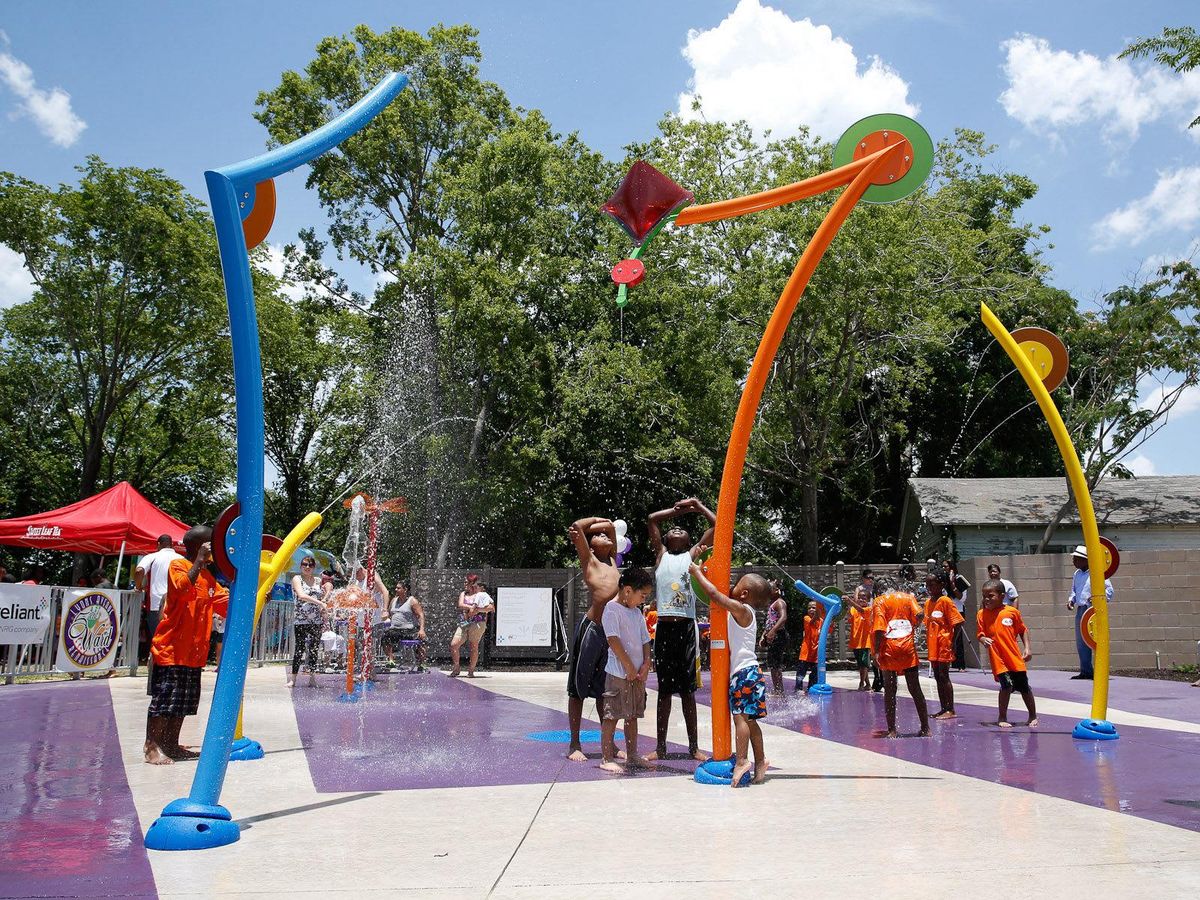 Children playing in a new solar powered splash pad in the Fifth Ward ...