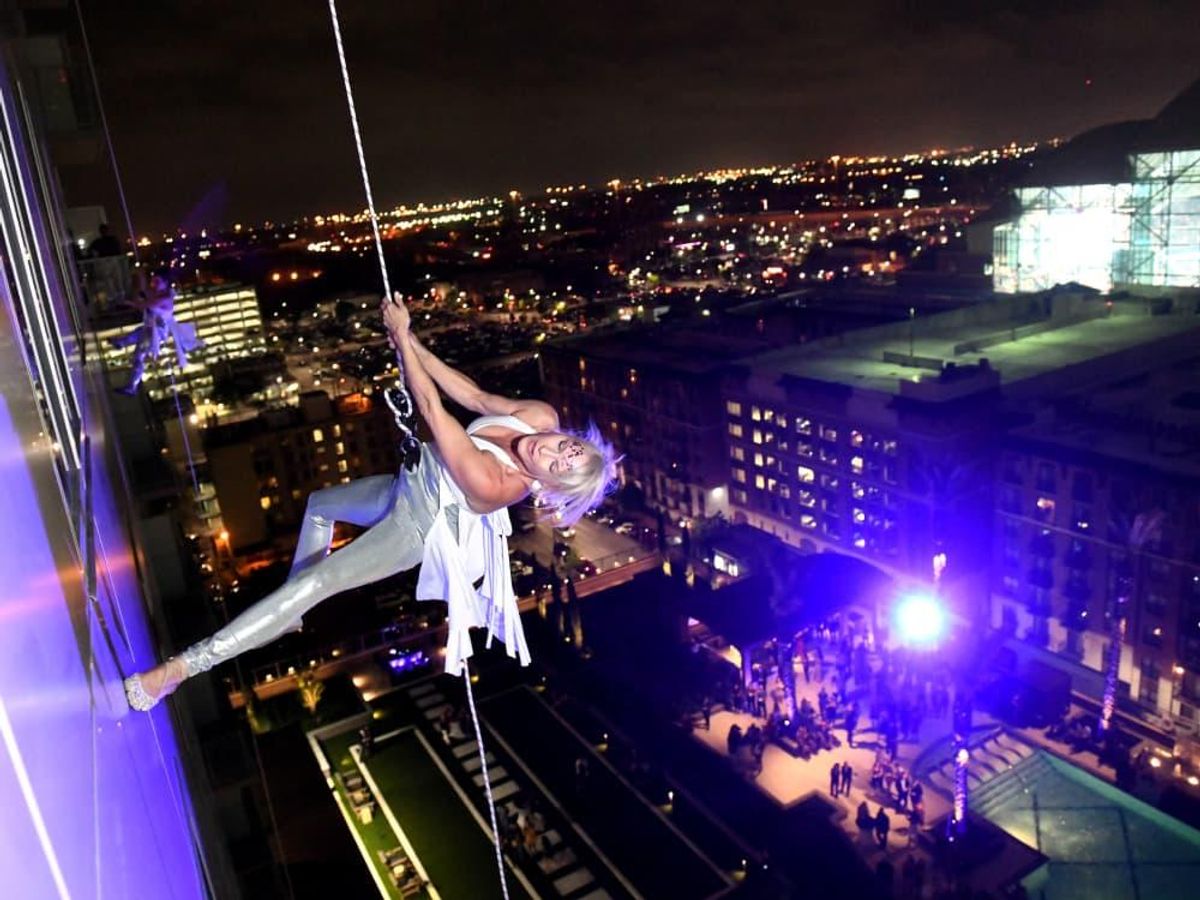 An aerial perfomer scales the Catalyst. - CultureMap Houston